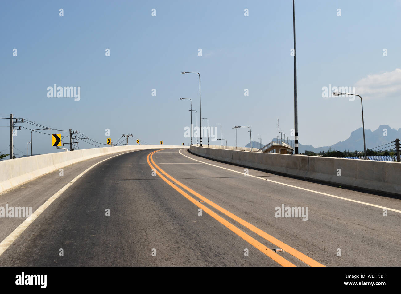 Open road on the bridge with mountain and blue sky in background ...