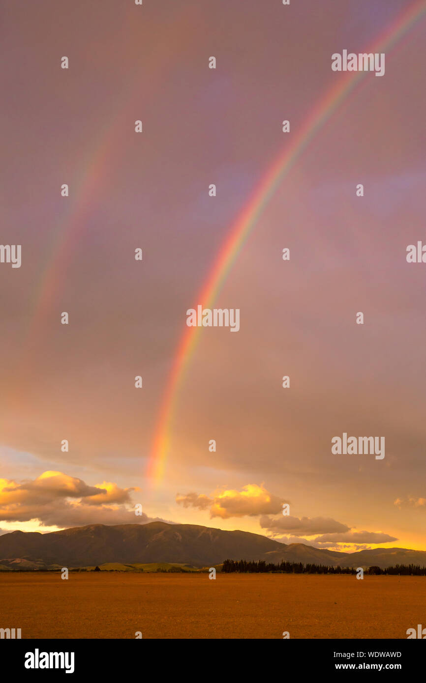 An evening rainbow lights up the evening sky in Canterbury, New Zealand ...