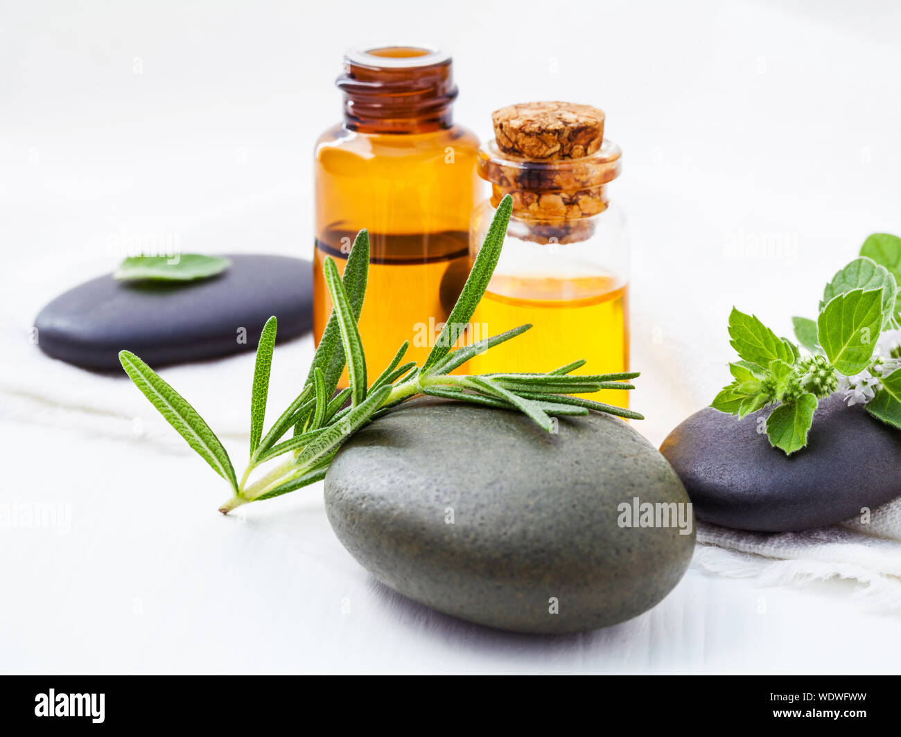 Close-up Of Herbs With Oil And Pebbles Over White Background Stock ...
