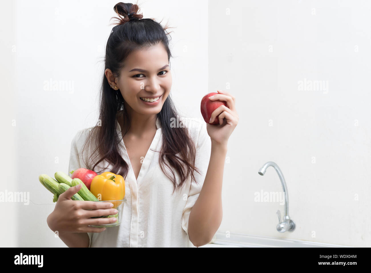 Young Woman Holding Fruits And Vegetables Against White Background ...