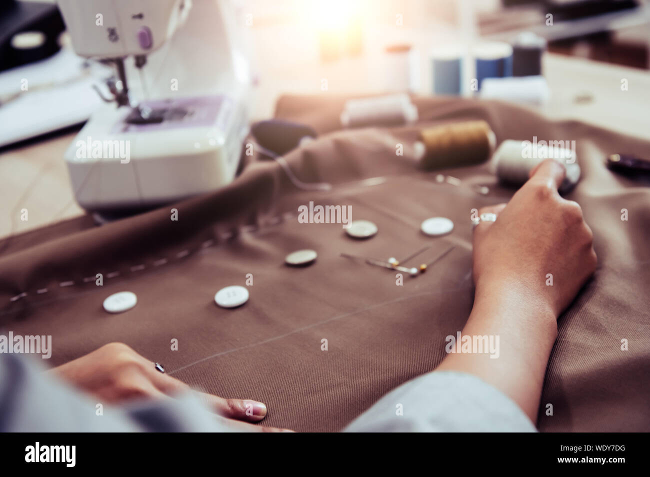 Dressmaker designing new fashion dress fabric with sewing machine ...