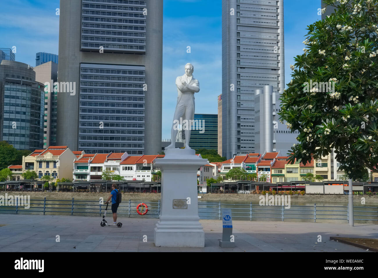A man on an e-scooter rides past the landmark Raffles Statue at Raffles ...