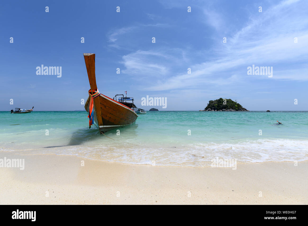 Wooden long-tail boat anchored on the beach in tropical sea at Lipe ...