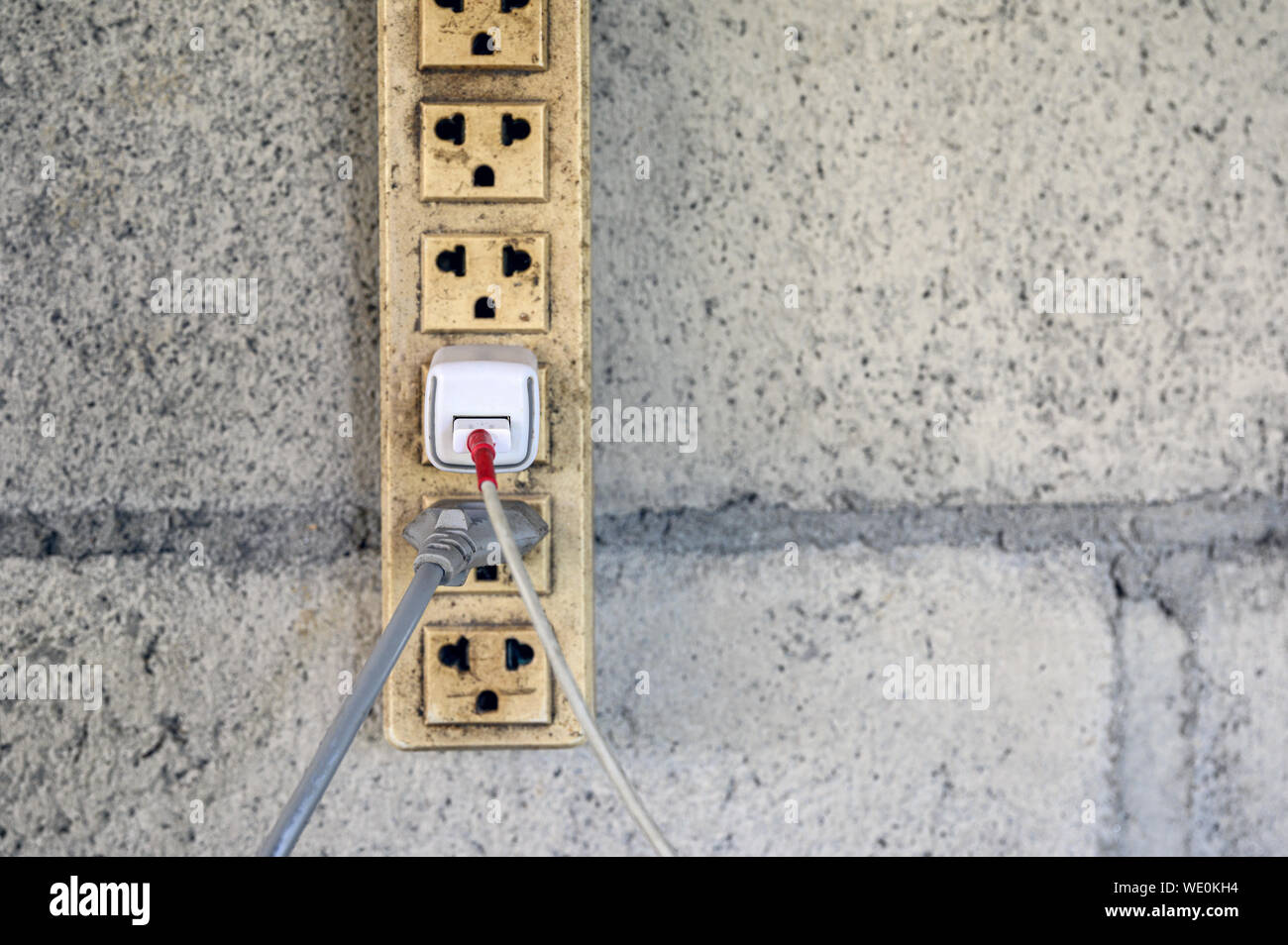 Old power electric plug with charging cable on brick wall Stock Photo ...