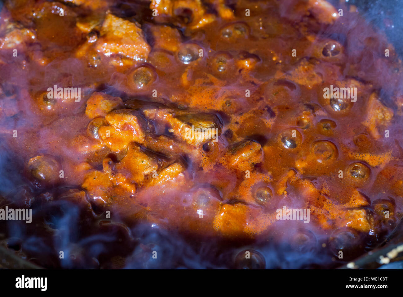 Cooking at home. Cooking meat with gravy. Fried pieces of meat in a pan ...