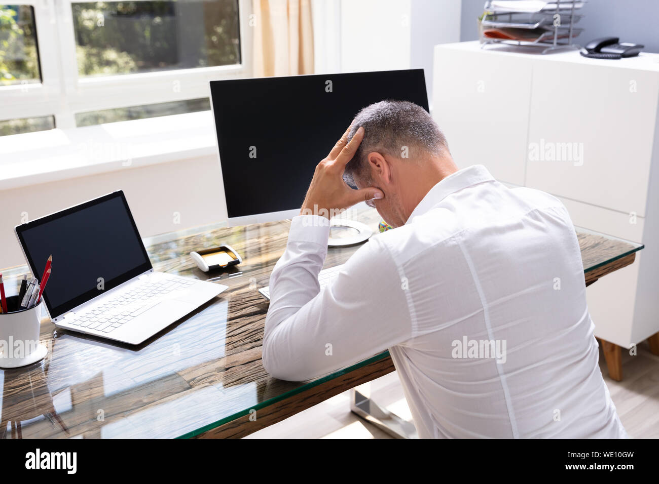 Sad entrepreneur sitting office desk hi-res stock photography and ...