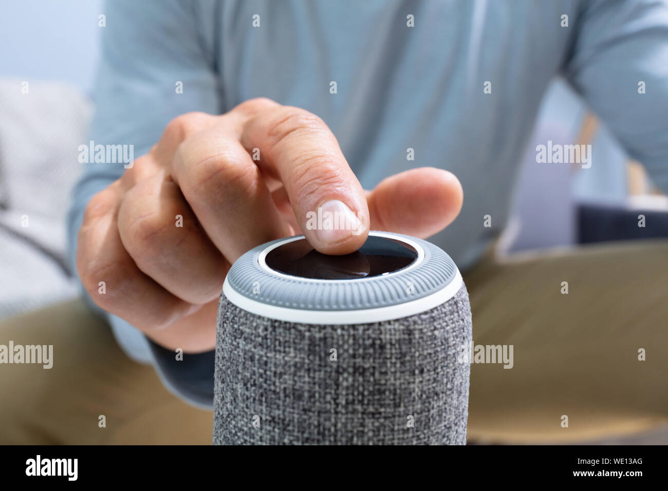 Man Pressing Button On Wireless Speaker At Home Stock Photo - Alamy