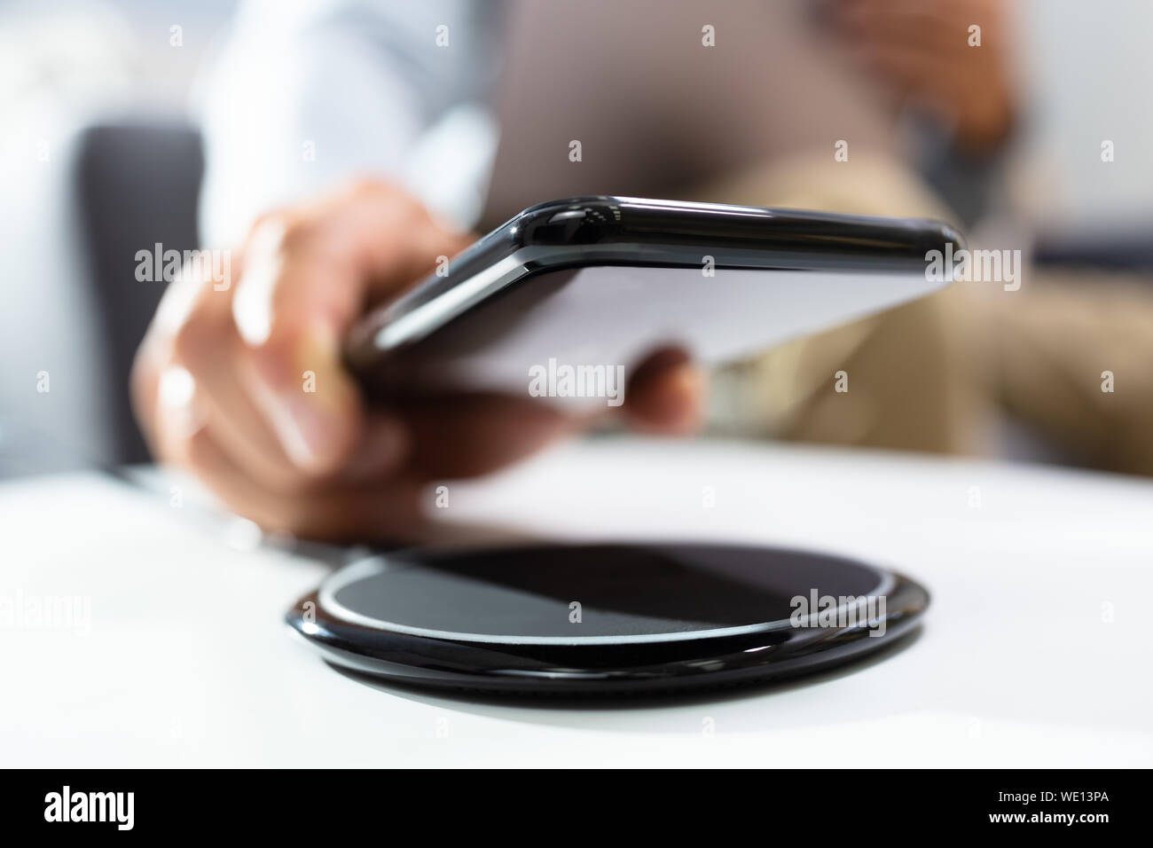 Man Charging Smartphone Using Wireless Charging Pad At Home Stock Photo ...