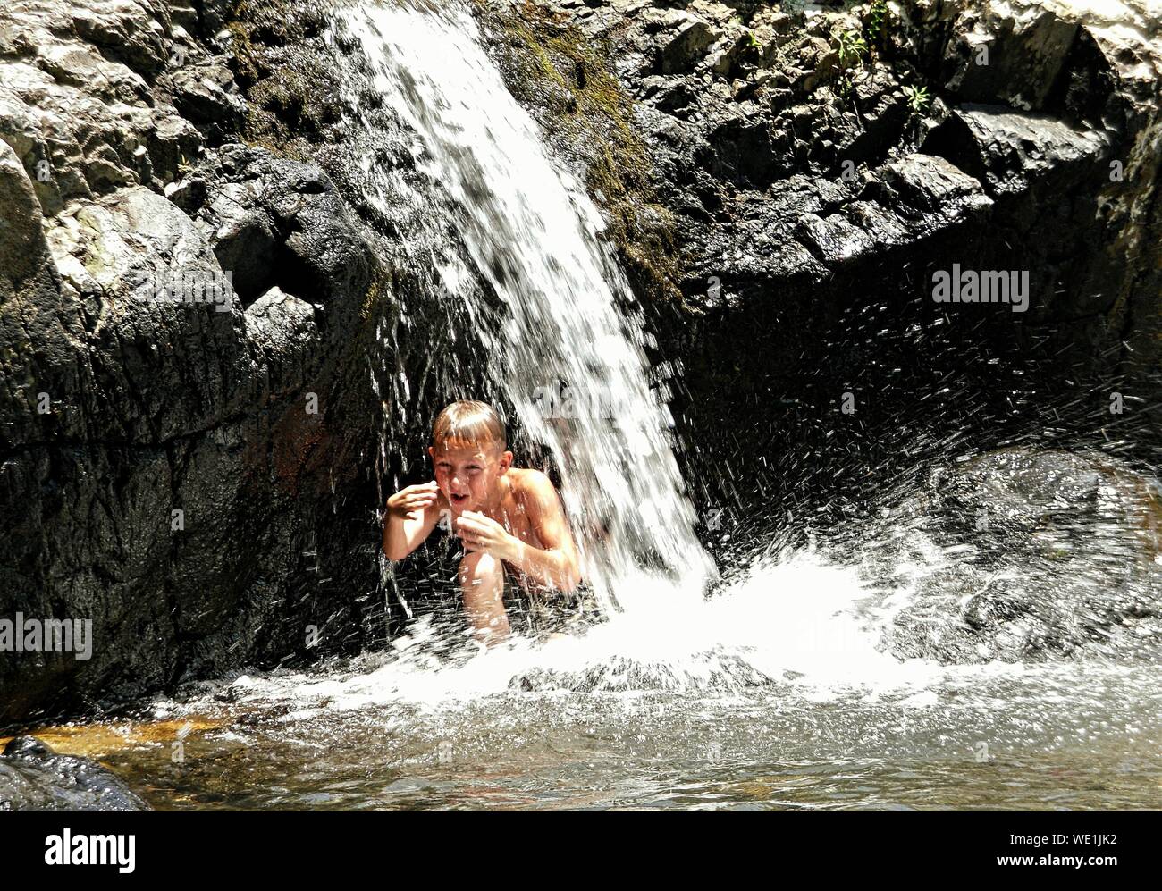 Boy in waterfall hi-res stock photography and images - Alamy