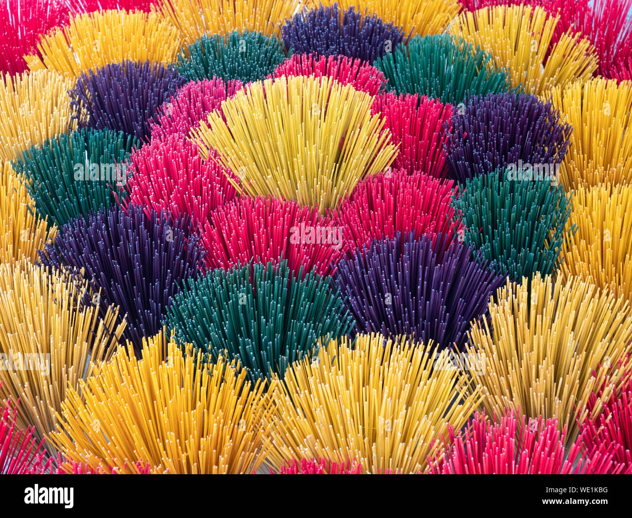Multiple incense sticks arranged by color and photographed from above ...