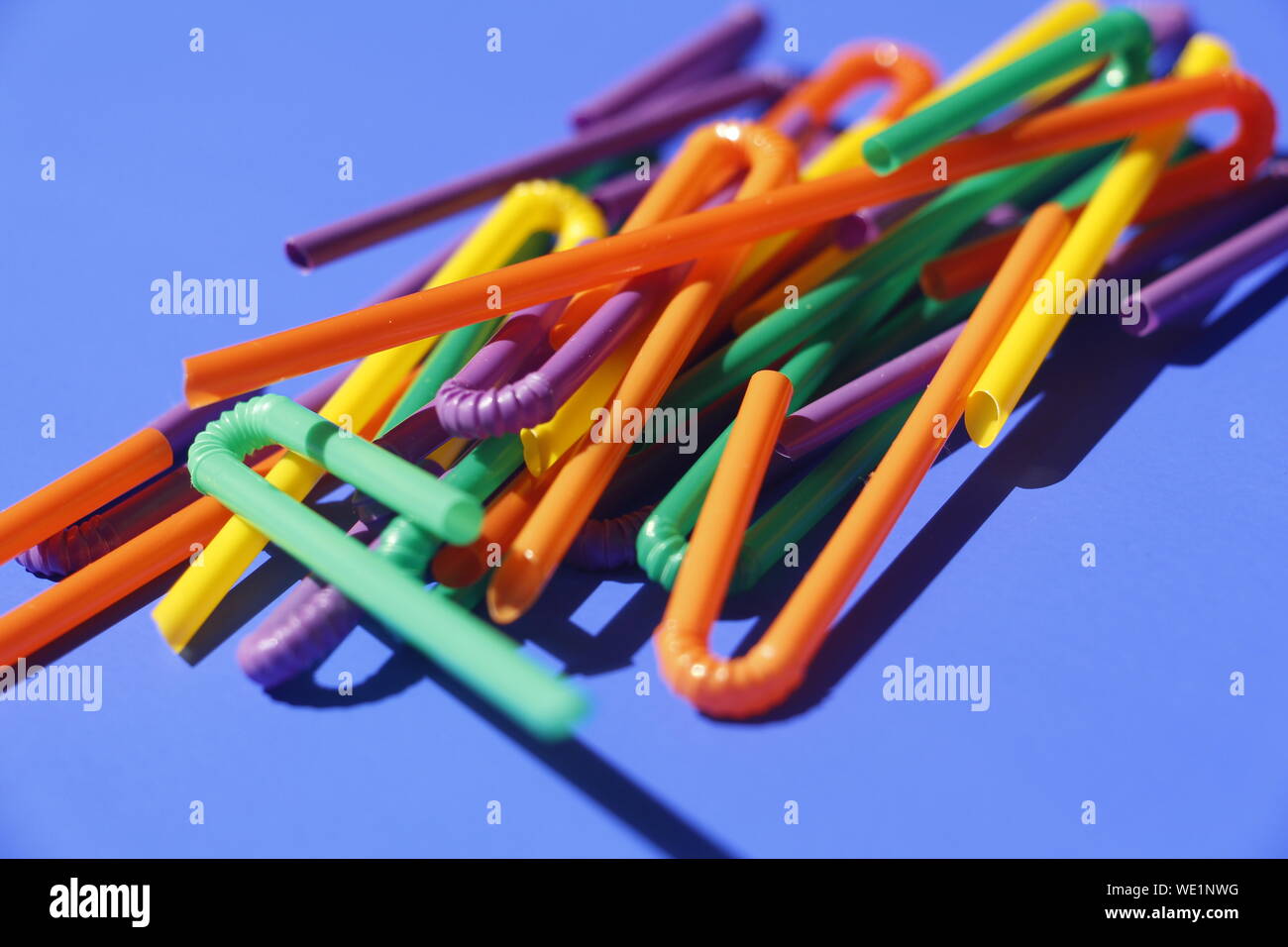 A lot of plastic tubules for drinks. Blue background. Close-up of straw ...