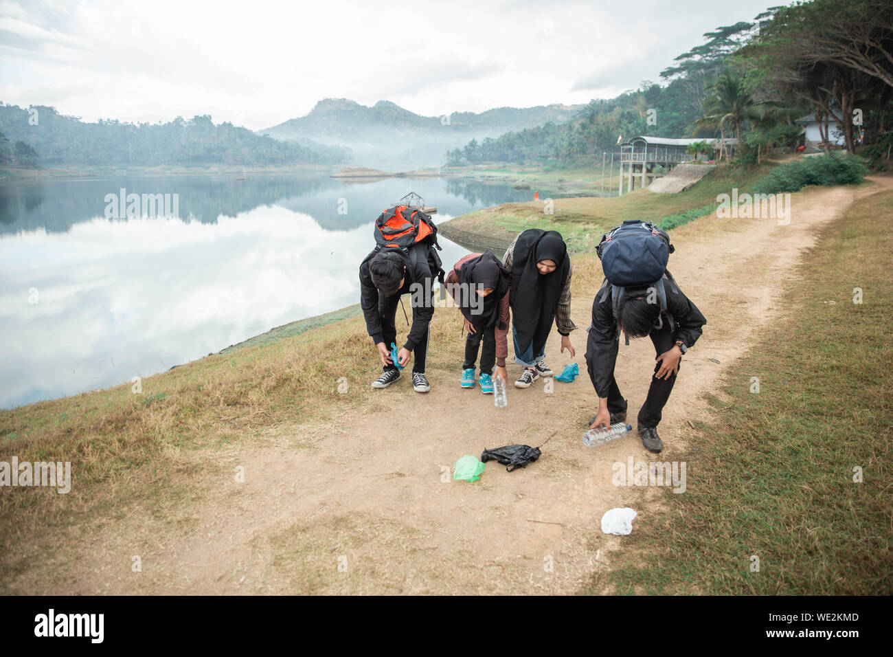 group of hikers picking up trash while camping Stock Photo - Alamy