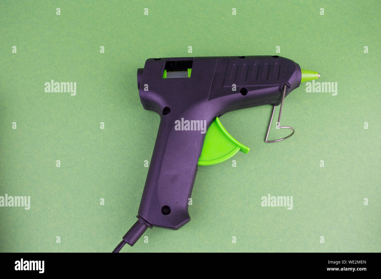 Hot melt gun for plastic soldering on a green background - black with a ...