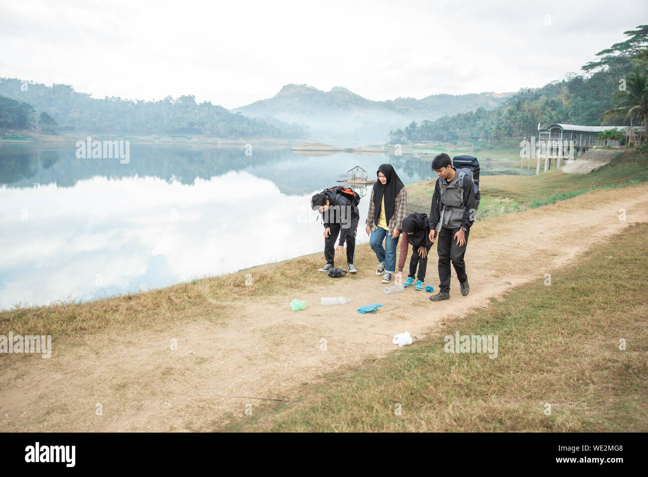 group of hikers picking up trash while camping Stock Photo - Alamy