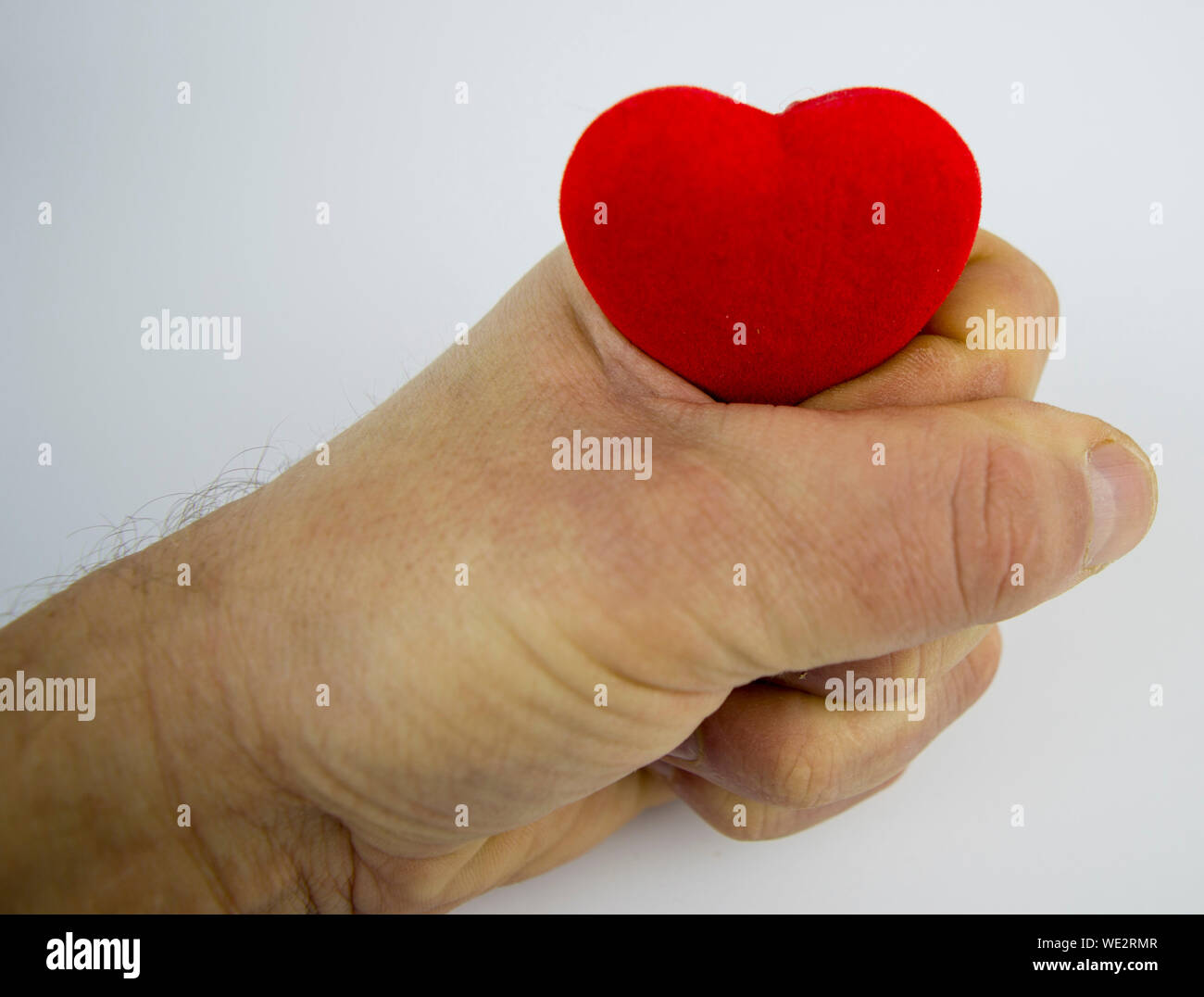 Heart in a man's fist on a white background, there is free space to ...