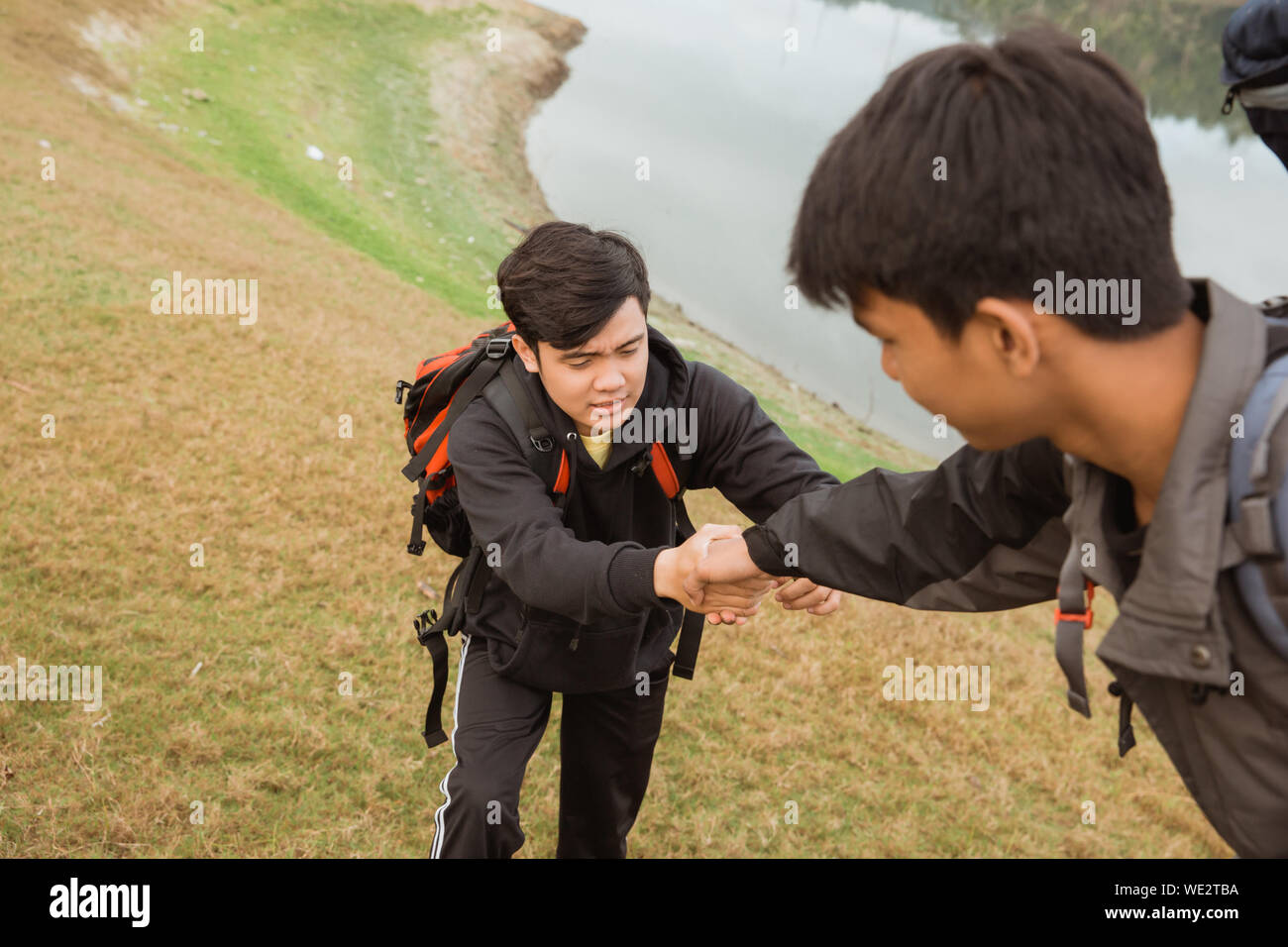 Two men hiking in mountain side the lake Stock Photo - Alamy