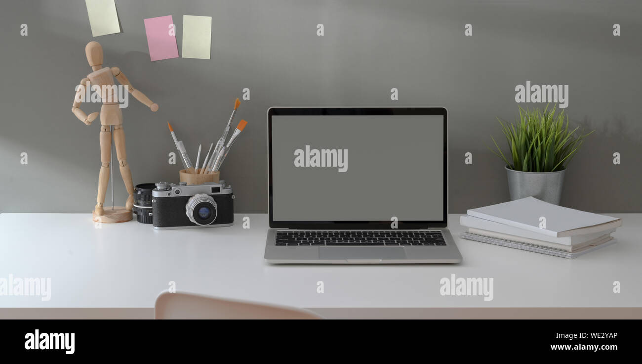 Open blank screen laptop computer with vintage camera and office ...