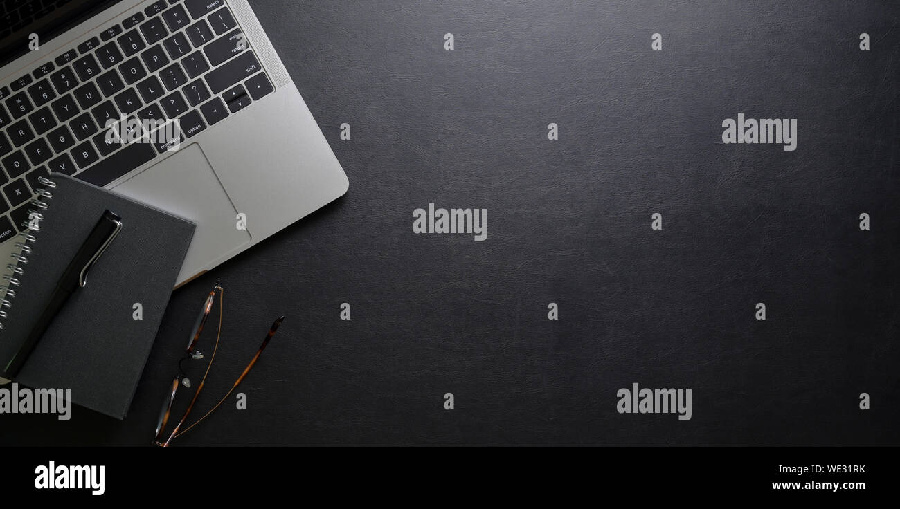 Top view of dark trendy workplace with laptop computer and office ...