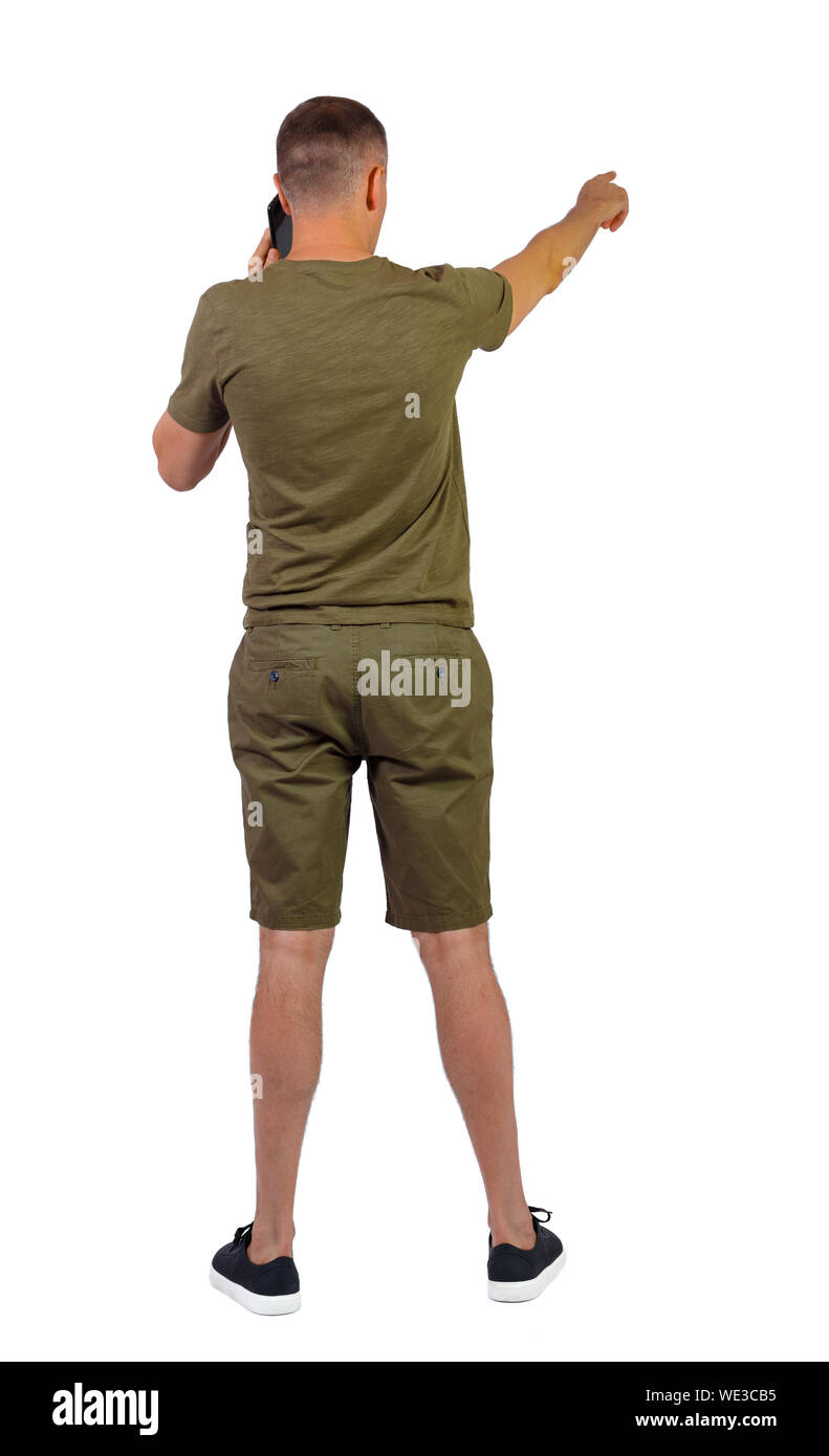Back view of pointing man in shorts who is looking into the smartphone ...
