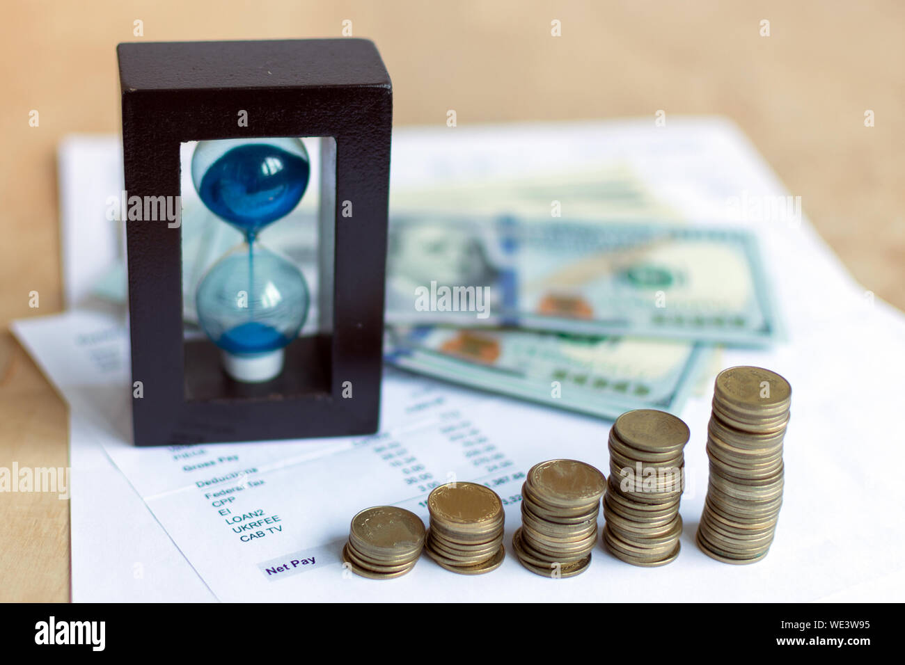 Hourglass and currency. Time is money concept Stock Photo - Alamy