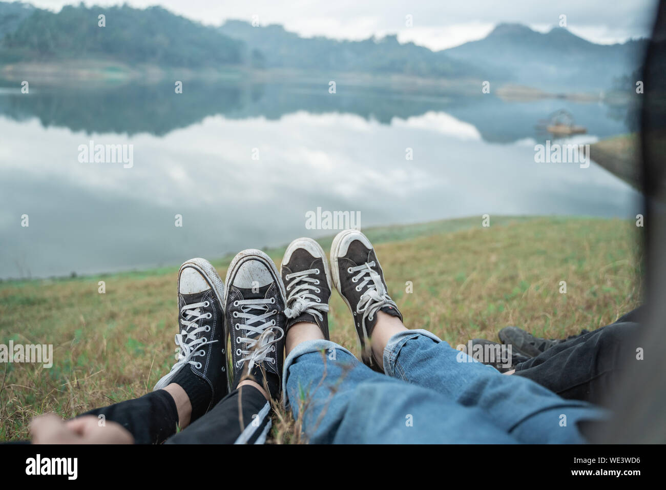 Hikers have relaxing time during an outdoor trekking sitting enjoy lake ...