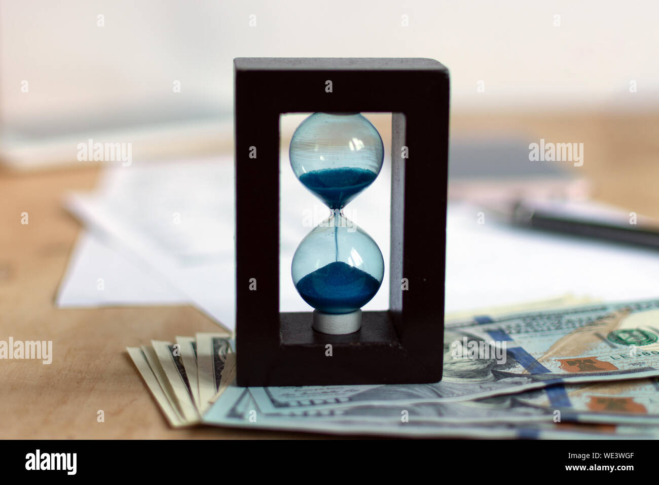 Hourglass and currency. Time is money concept Stock Photo - Alamy