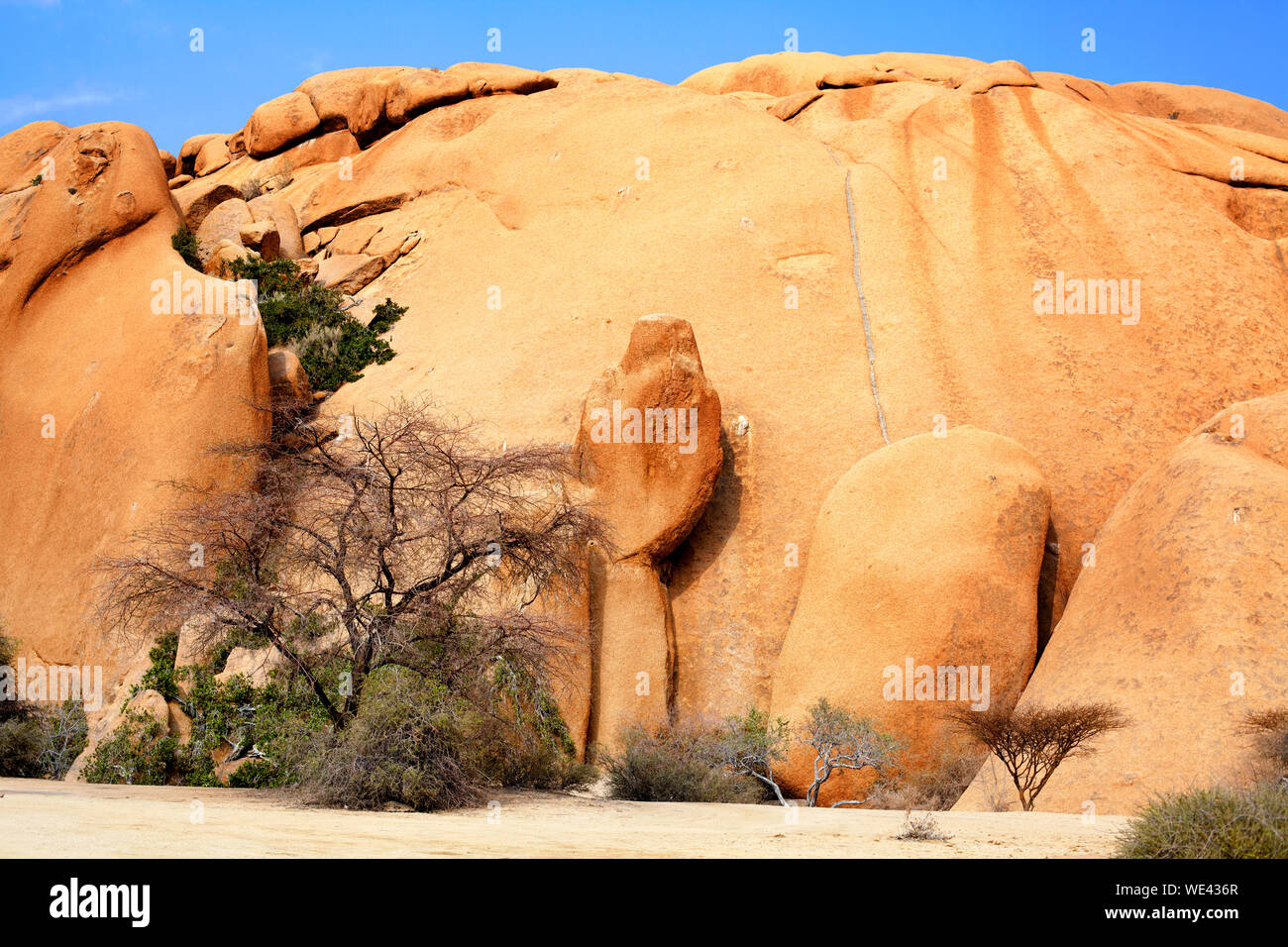 Red bald granite peaks on blue sky background, ancient geological ...
