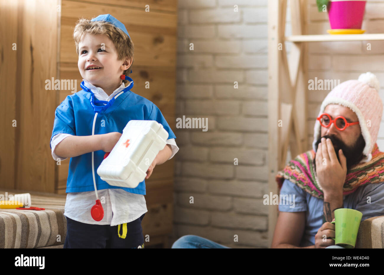Cute smiling boy playing doctor with father. Physician with first aid ...