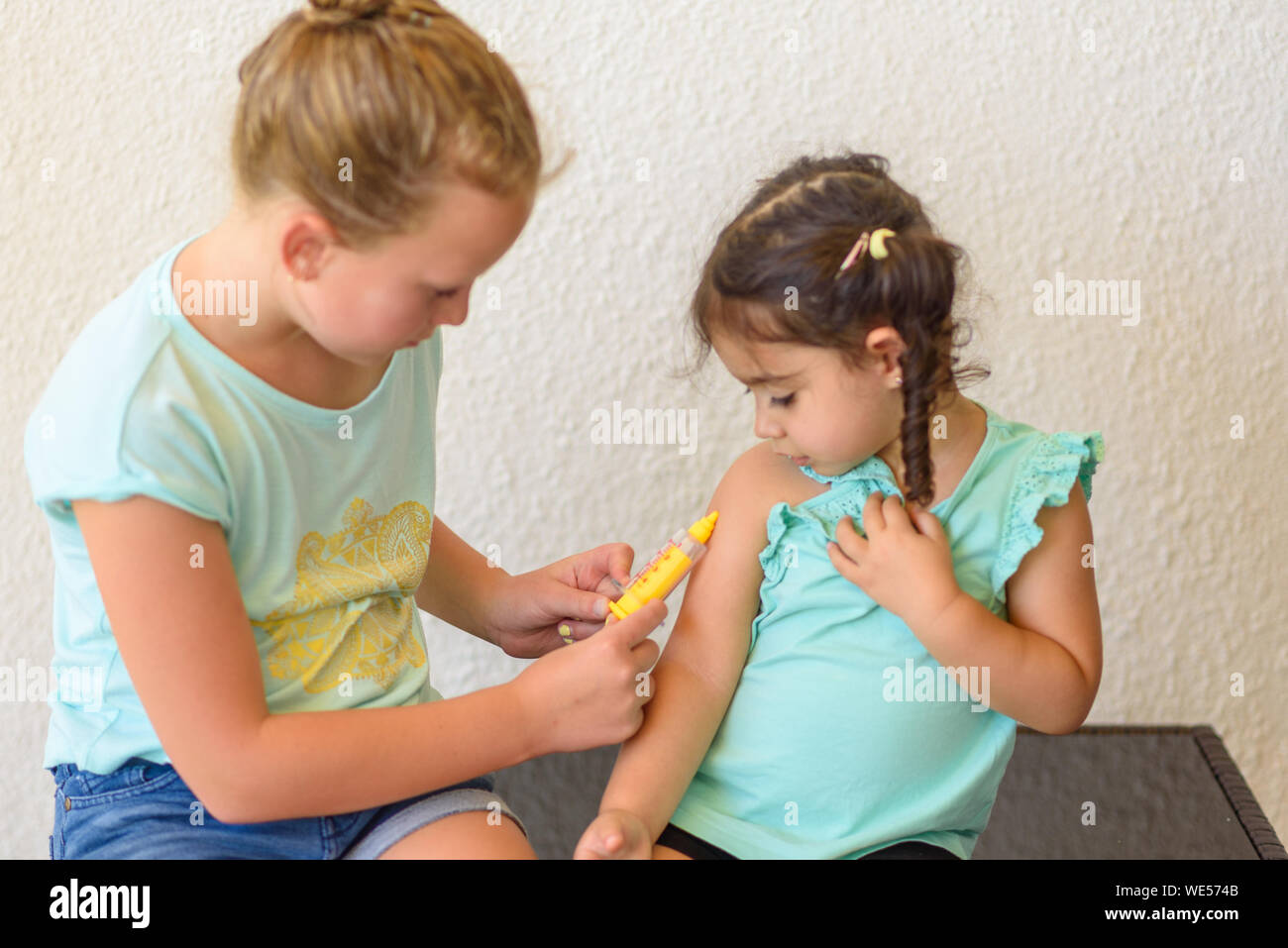 Children playing doctor. Doctor injecting vaccination Flu Shot in arm ...