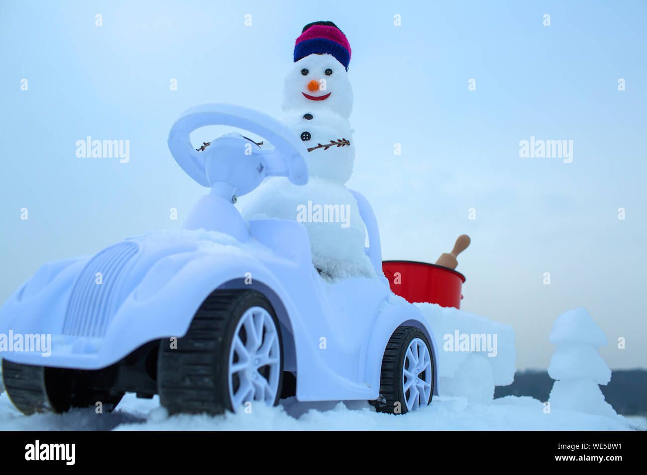 Snowman and toy car on snowy background Stock Photo - Alamy