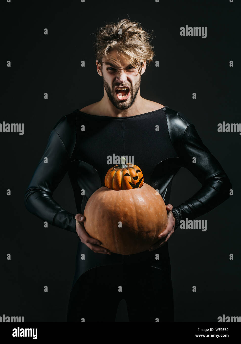 Halloween macho with angry face in black costume Stock Photo - Alamy