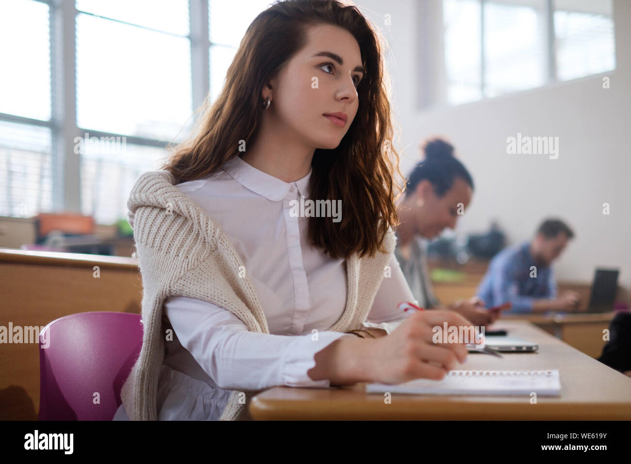 Beautiful girl taking notes in multinational group of students in an ...