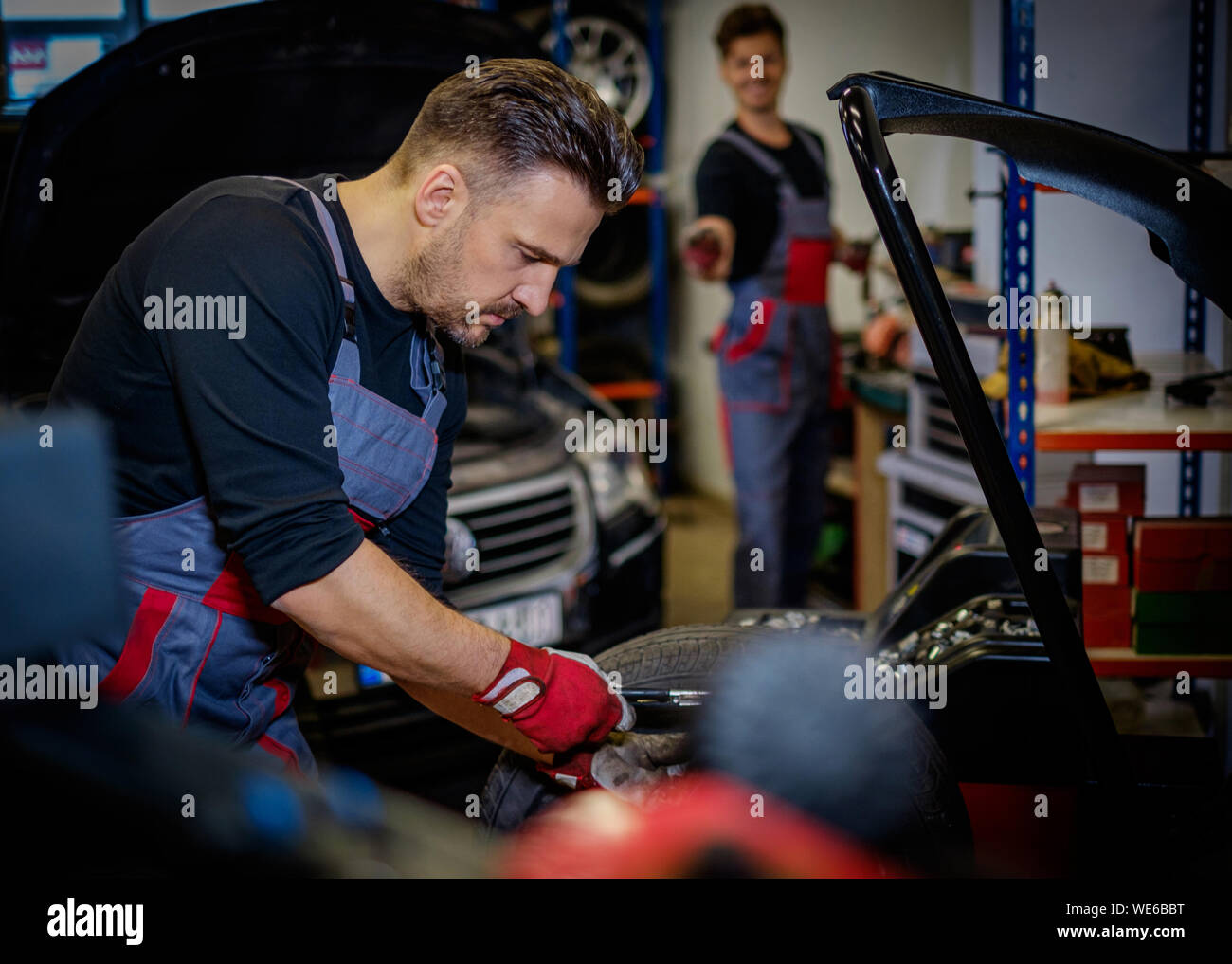 Car mechanic mounts tire on wheel in a workshop Stock Photo - Alamy