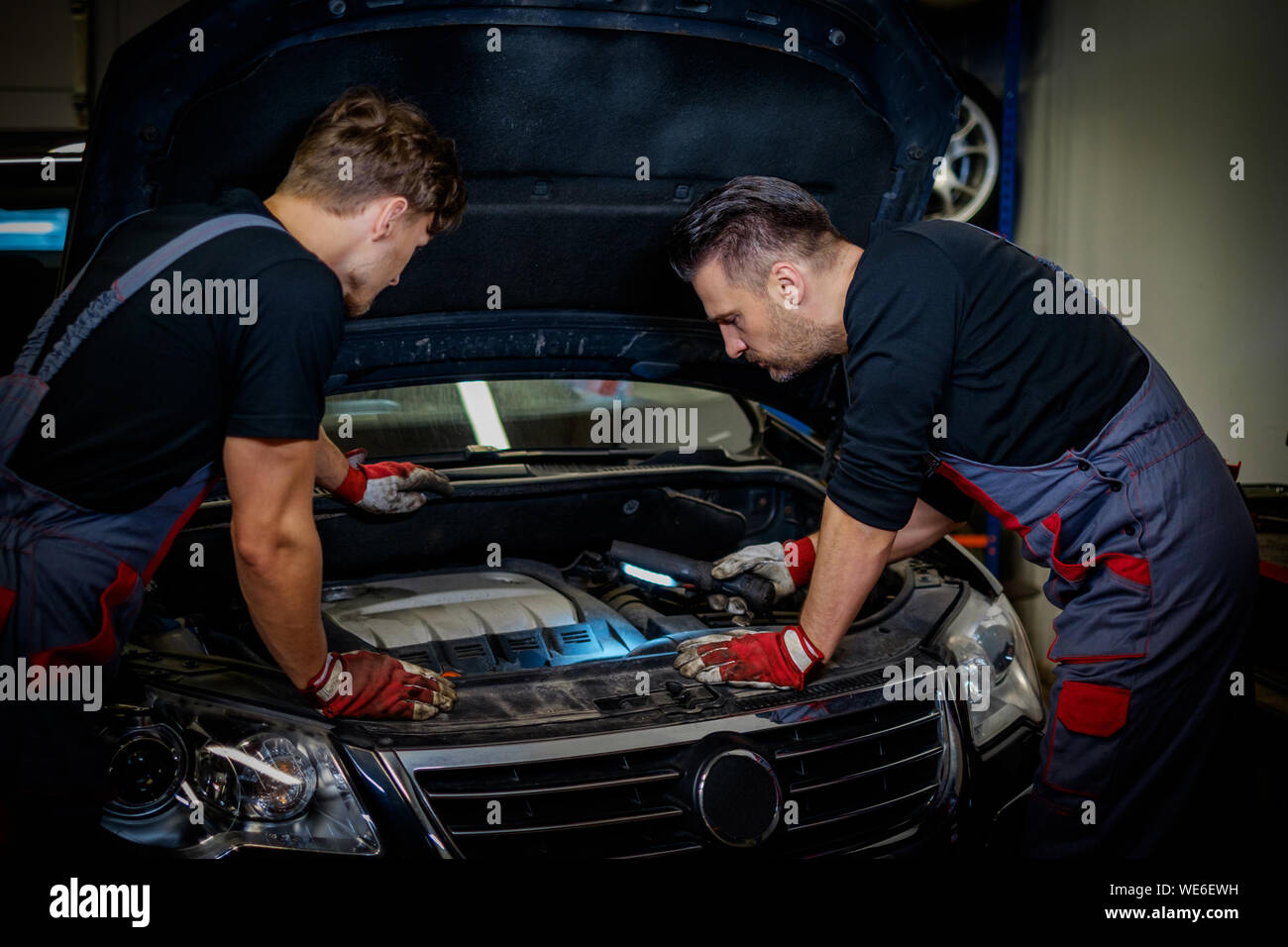 Mechanic examining under hood car hi-res stock photography and images ...