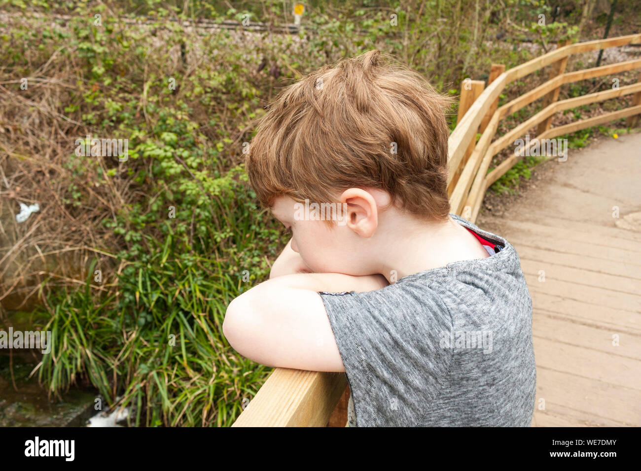 A young boy looking over a footbridge Stock Photo - Alamy