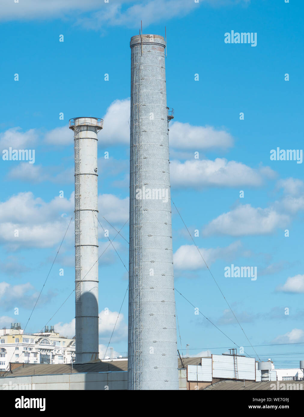 Pipes of an industrial enterprise against a blue sky with clouds ...