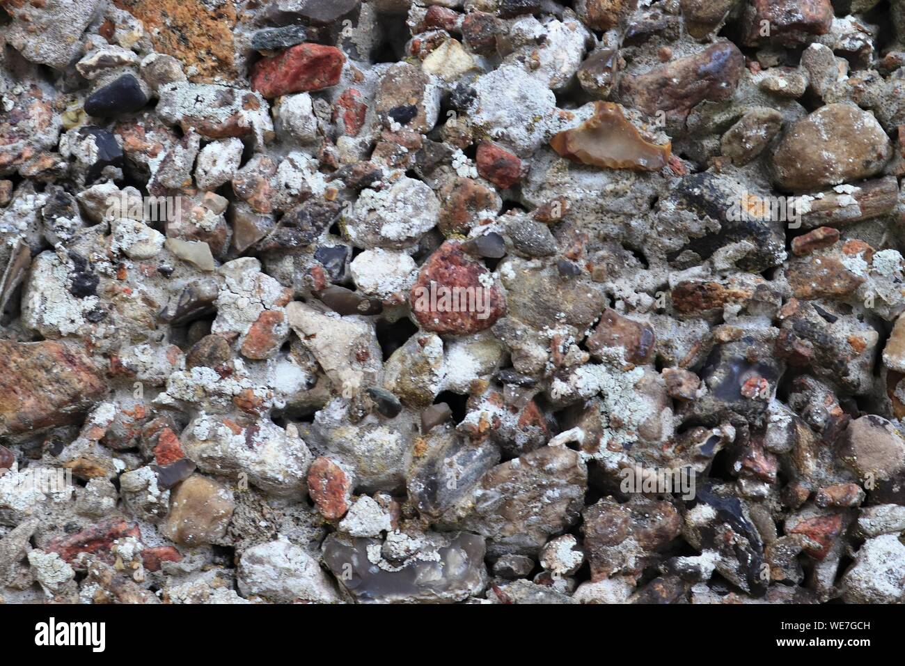 Detailed close up view on pebbles and stones on a gravel ground texture ...