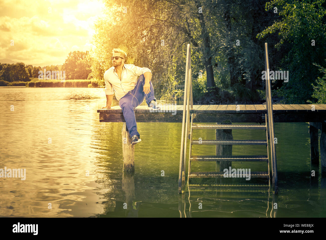 Man sitting jetty looking lake hi-res stock photography and images - Alamy