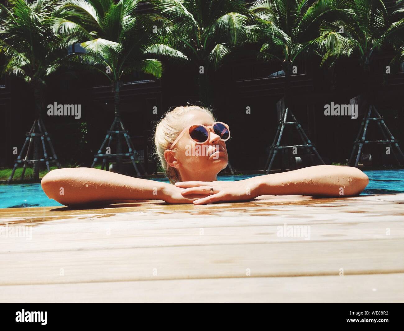 Woman relaxing by swimming pool hi-res stock photography and images - Alamy