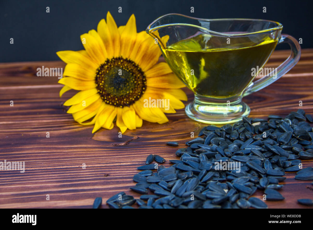 wooden background with sunflower oil, seeds and a sunflower Stock Photo ...