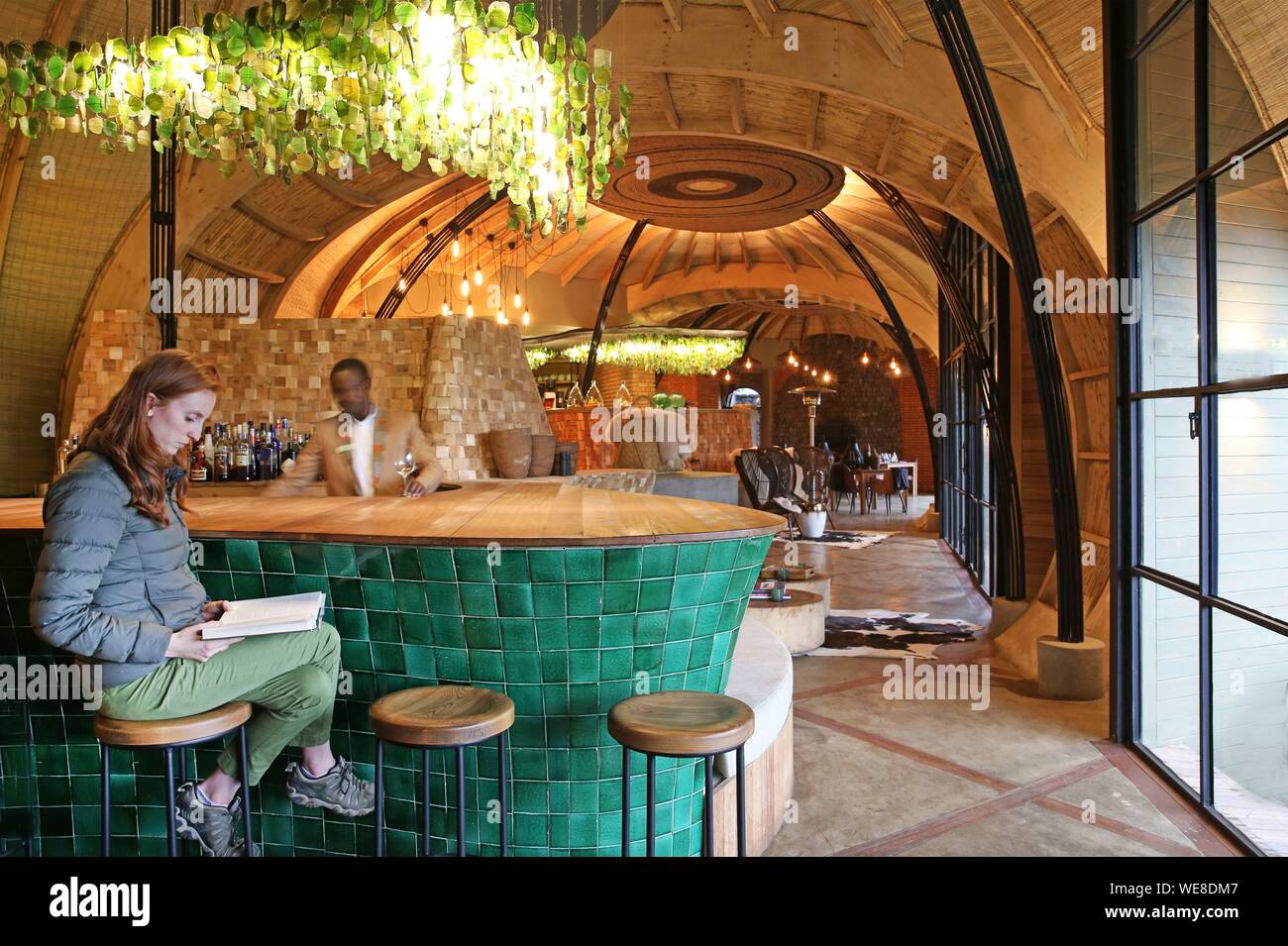 Rwanda, Volcanoes National Park, customer sitting at the bar of Bisate ...