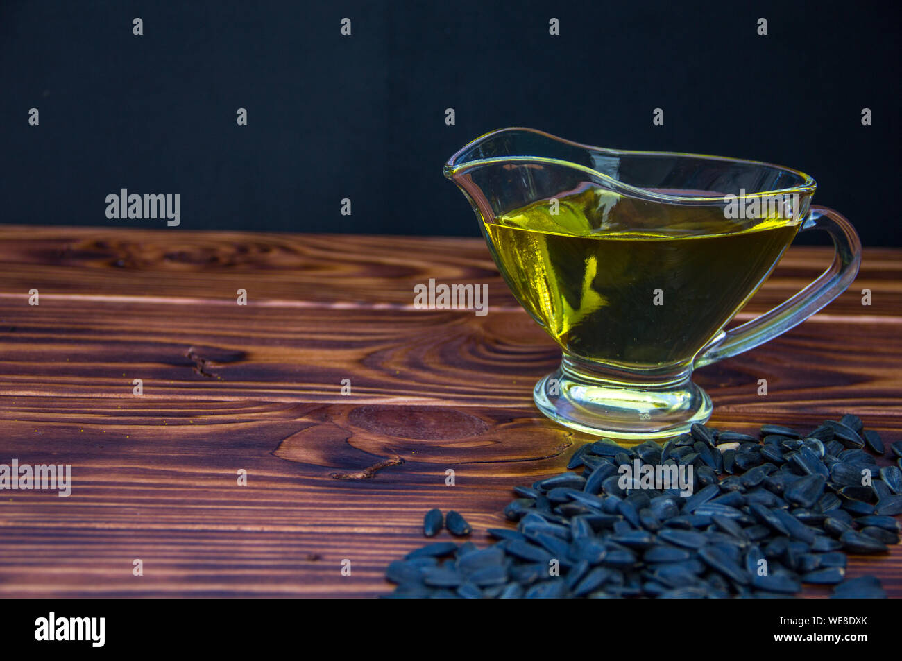 wooden background with sunflower oil and seeds Stock Photo - Alamy