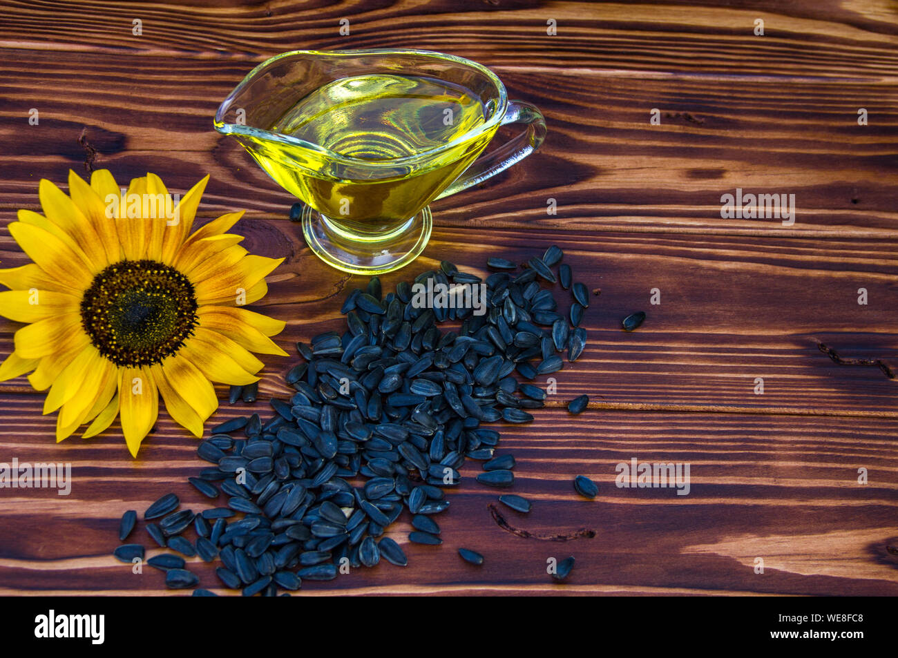 wooden background with sunflower oil, seeds and a sunflower Stock Photo ...