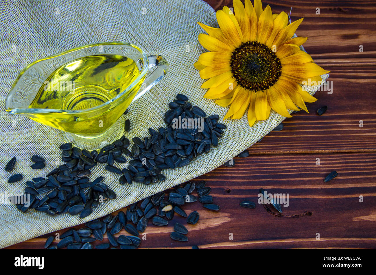 wooden background with sunflower oil, seeds and a sunflower Stock Photo ...