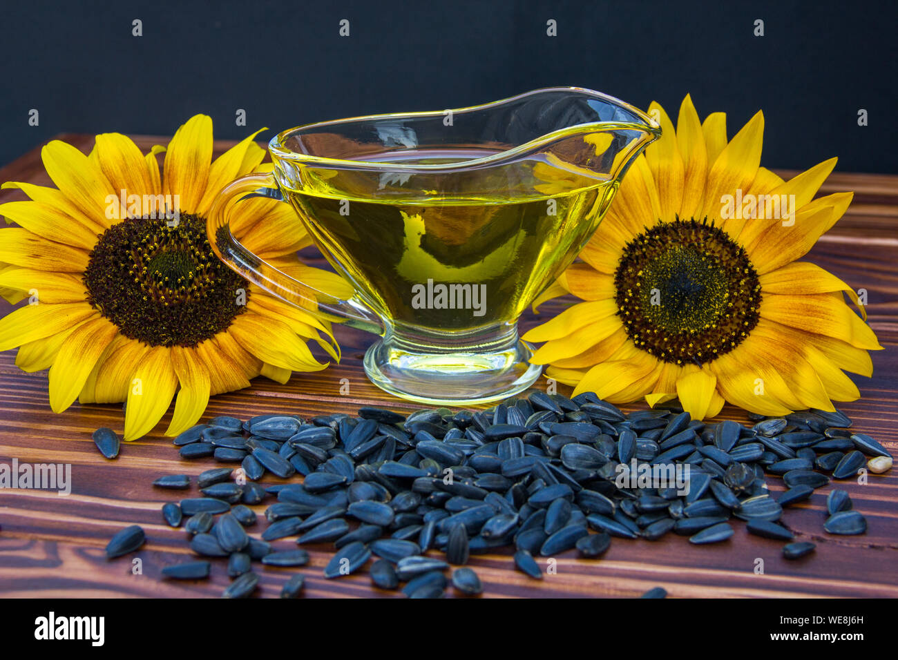 wooden background with sunflower oil, seeds and a sunflower Stock Photo ...