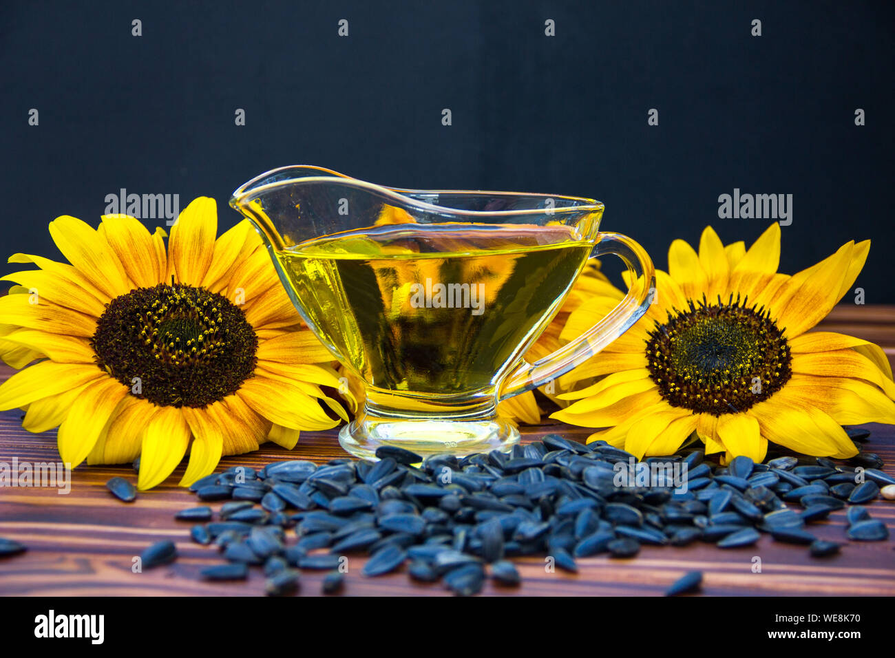 wooden background with sunflower oil, seeds and a sunflower Stock Photo ...