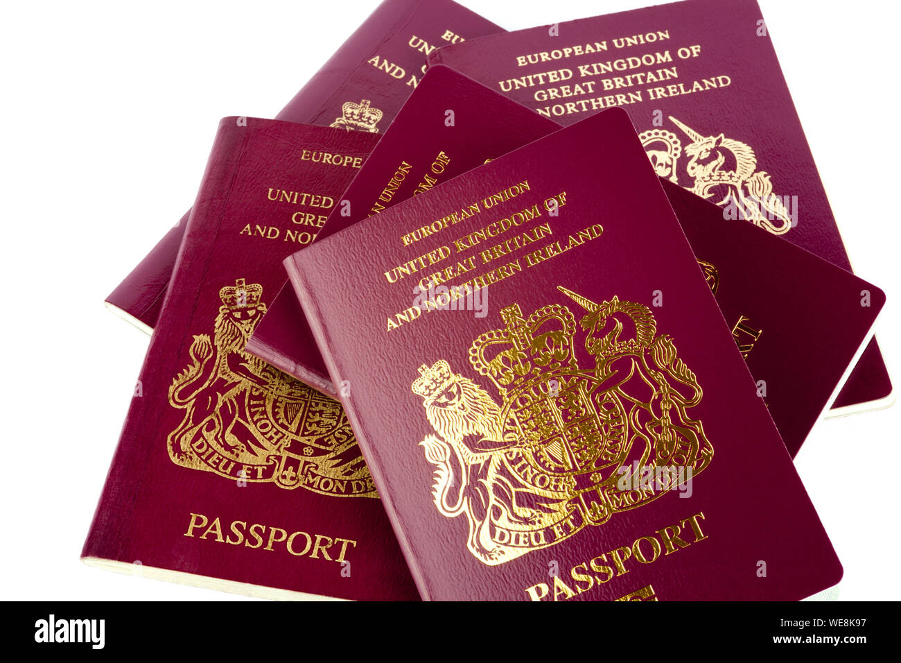 A stack of old and new UK passports isolated on a white background ...