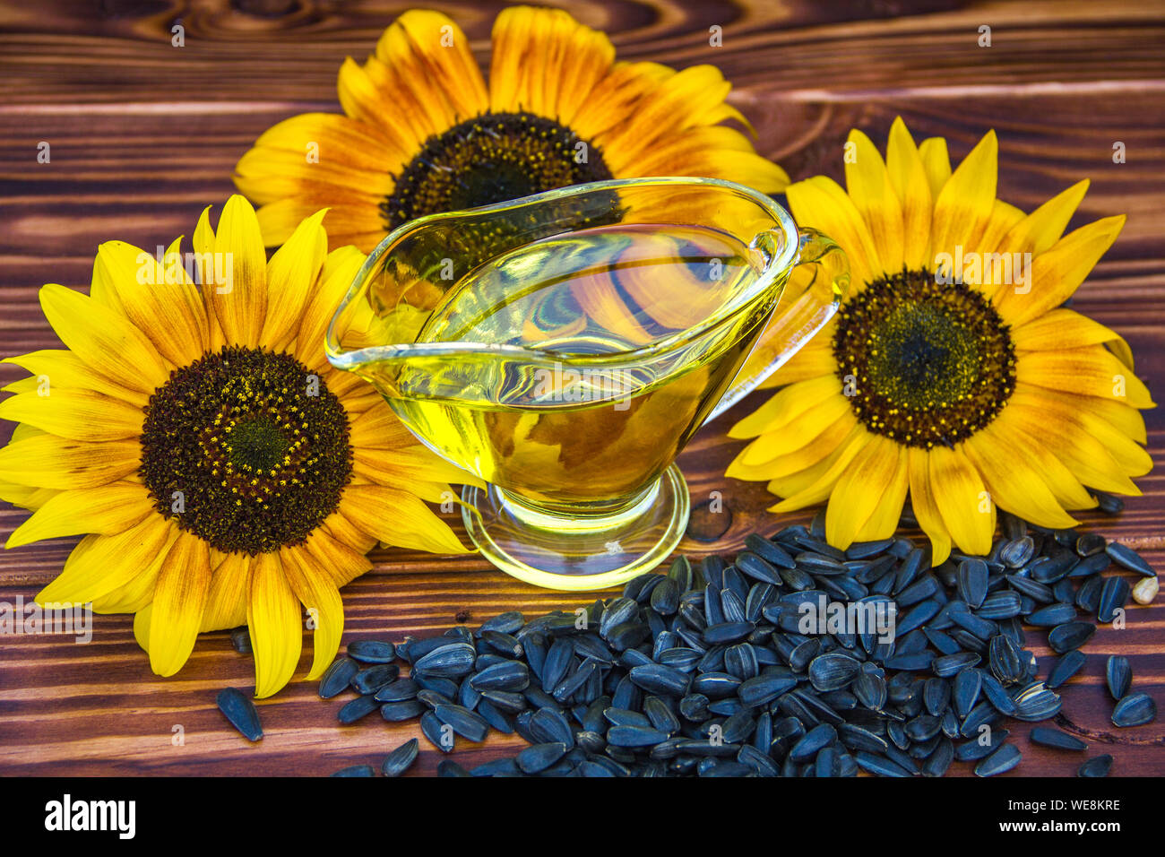 wooden background with sunflower oil, seeds and a sunflower Stock Photo ...
