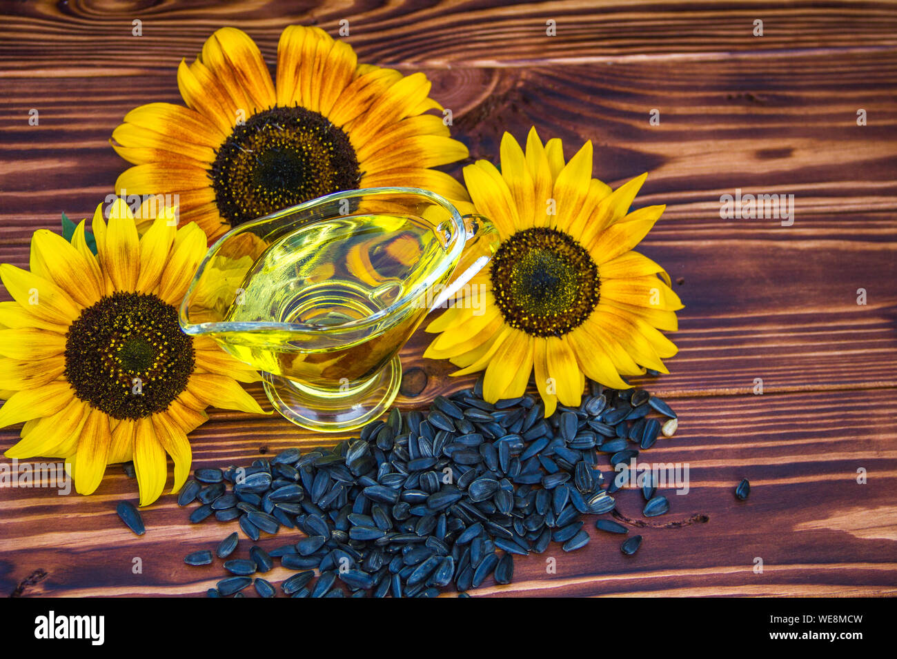 wooden background with sunflower oil, seeds and a sunflower Stock Photo ...