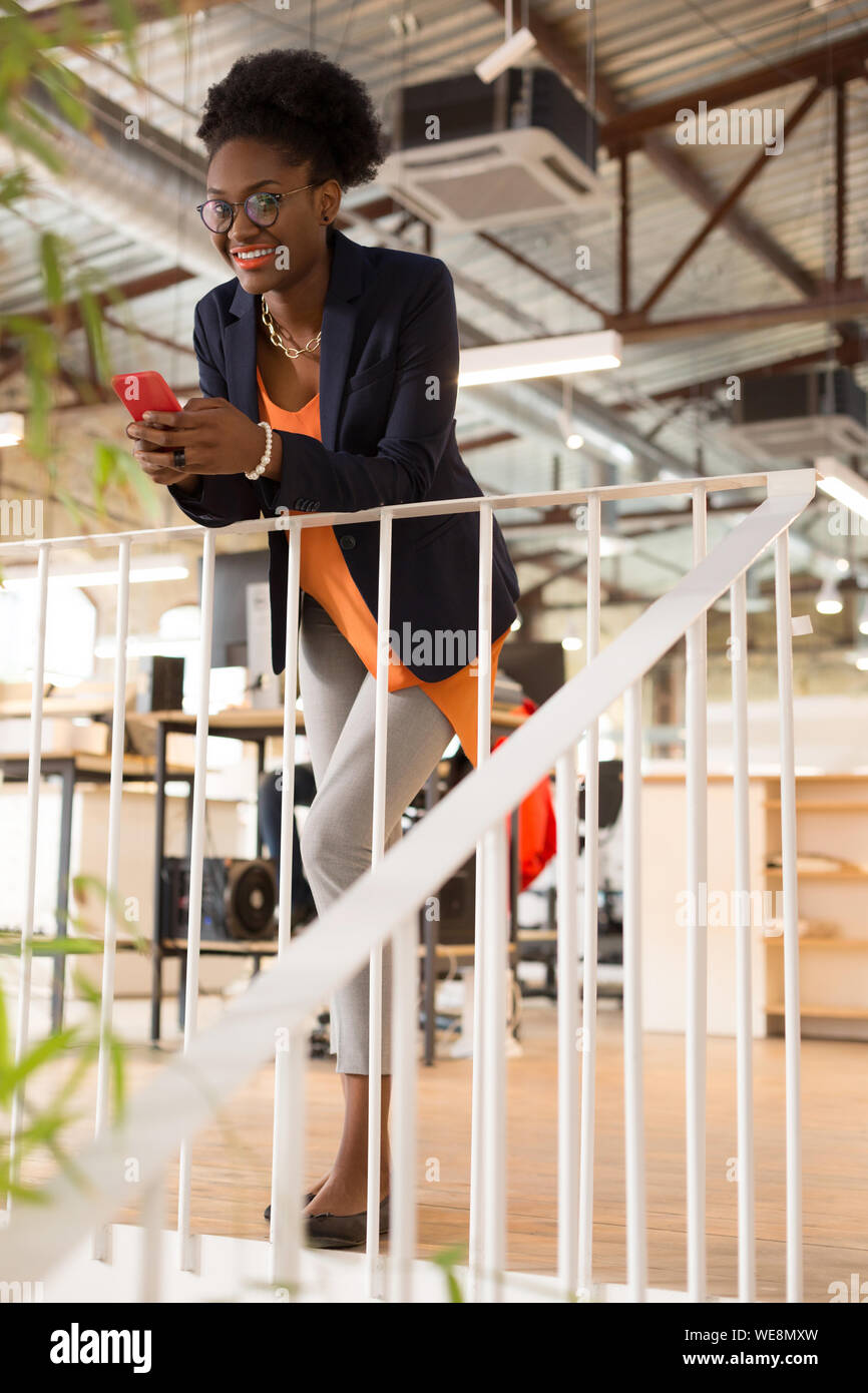 Office worker wearing stylish jacket holding smartphone Stock Photo - Alamy